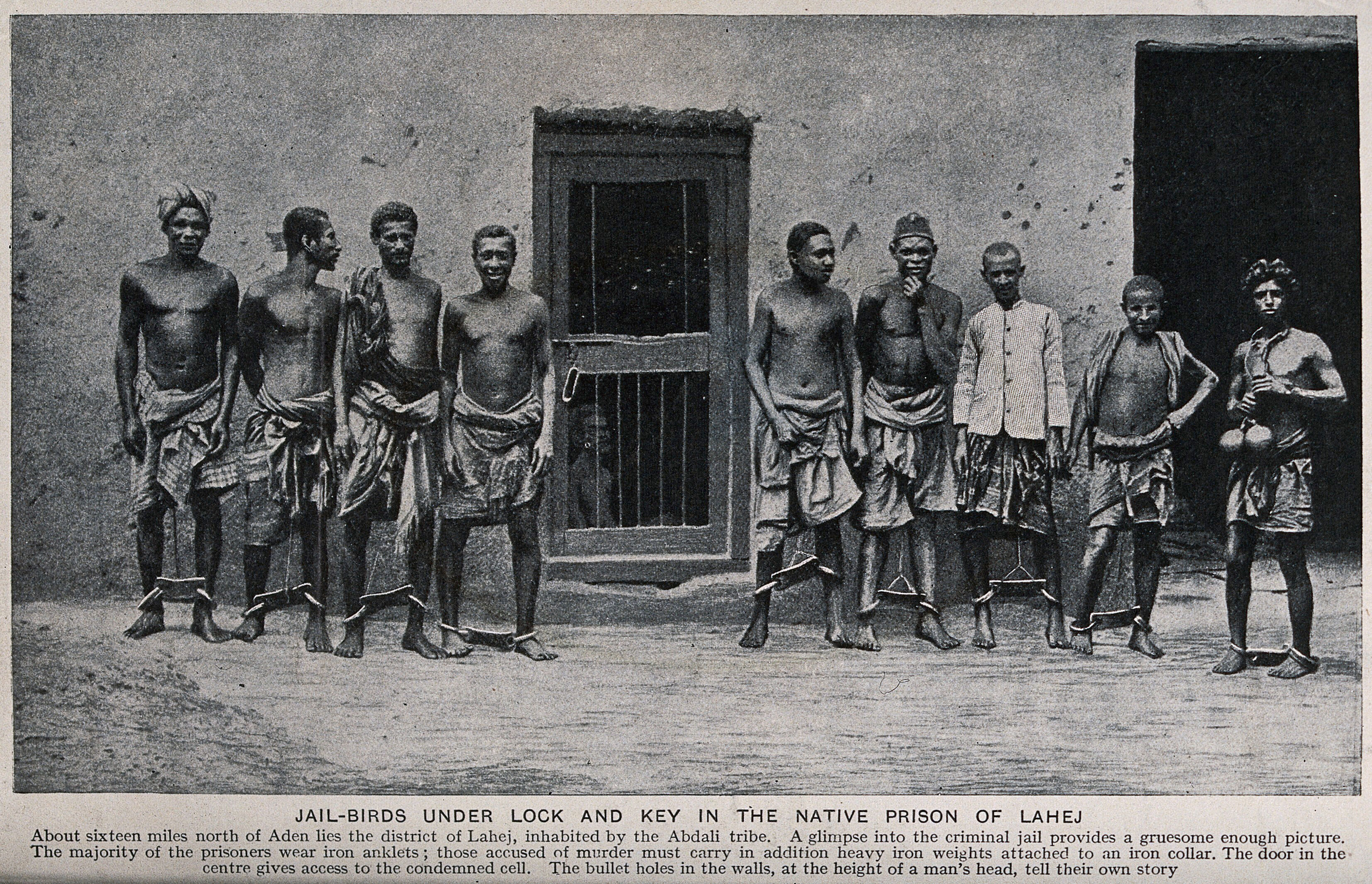 Nine male prisoners In Yemen wearing leg irons. Process print ...